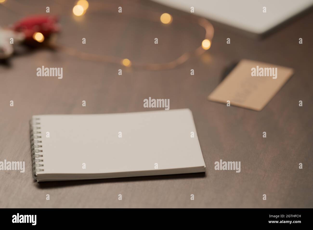 White empty paper notepad with christmas decorations on walnut table ...