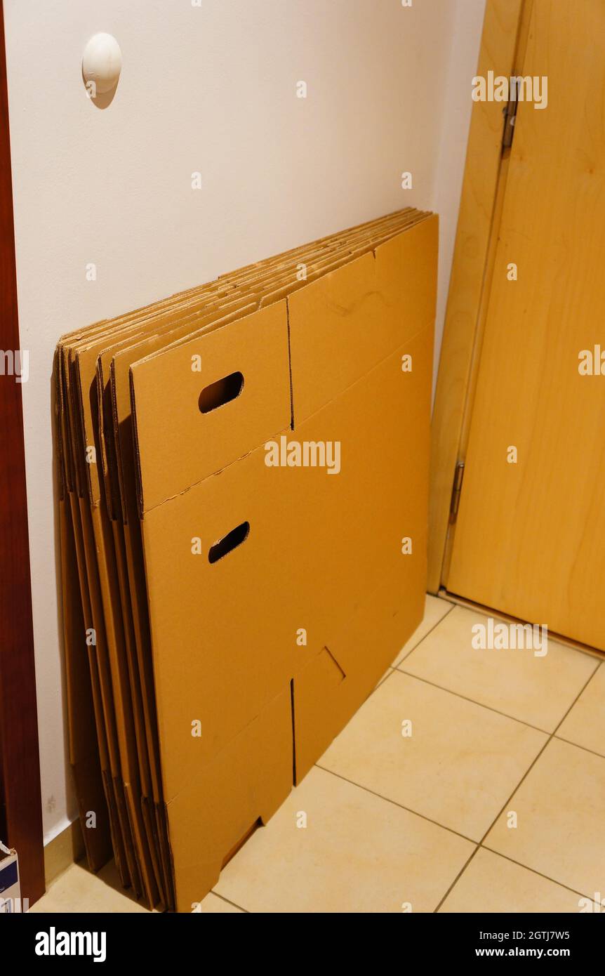 Shot of unassembled cardboard boxes against the white wall in the ...