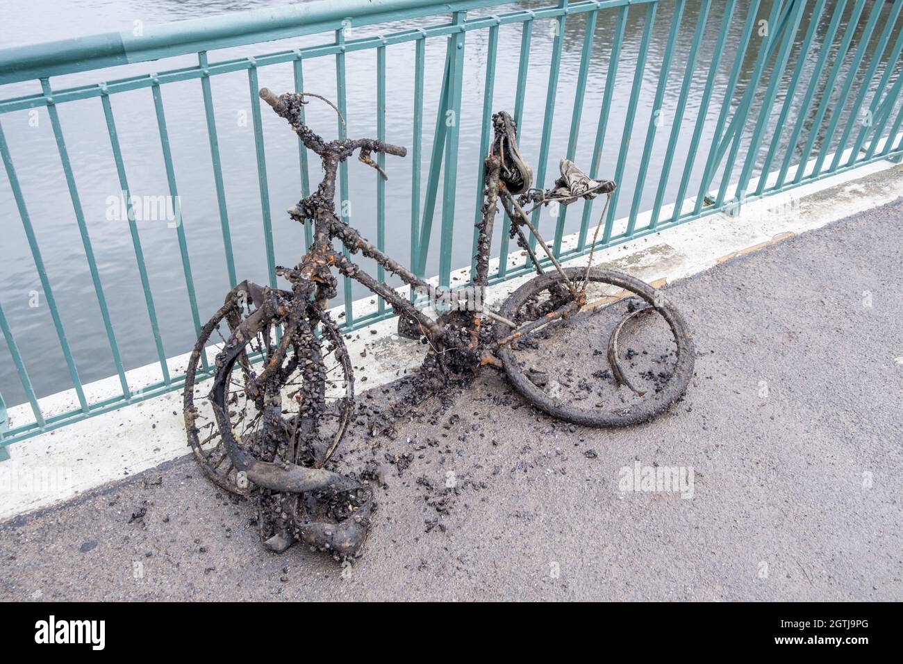old destroyed bicycle out of. water lying on bridge Stock Photo - Alamy