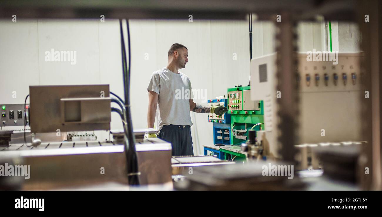 Professional worker technician machinist work in factory production ...