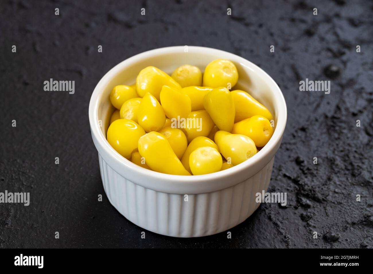 yellow hot pepper pickle on dark background Stock Photo - Alamy