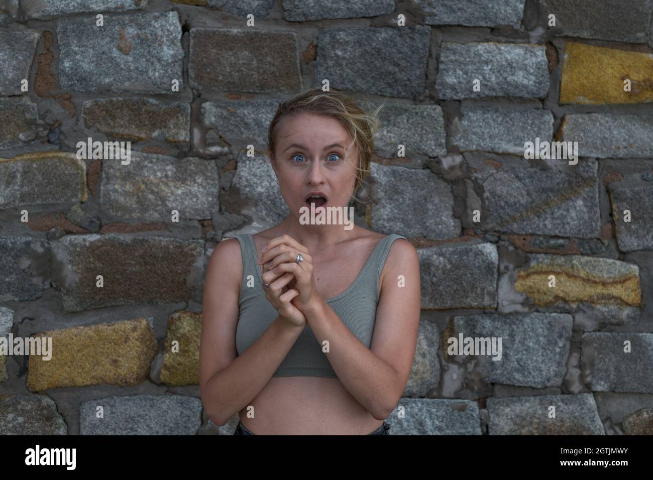 Portrait of surprised young caucasian woman on the stone background ...
