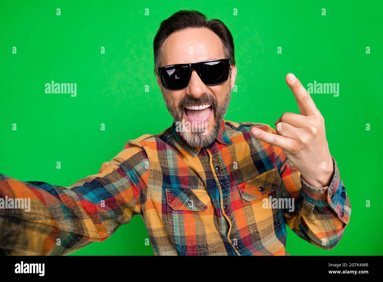 Self-portrait of attractive cheerful man showing horn sign fooling ...