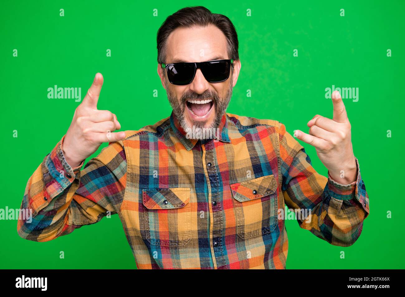 Portrait of attractive cheerful man showing double horn sign having fun ...