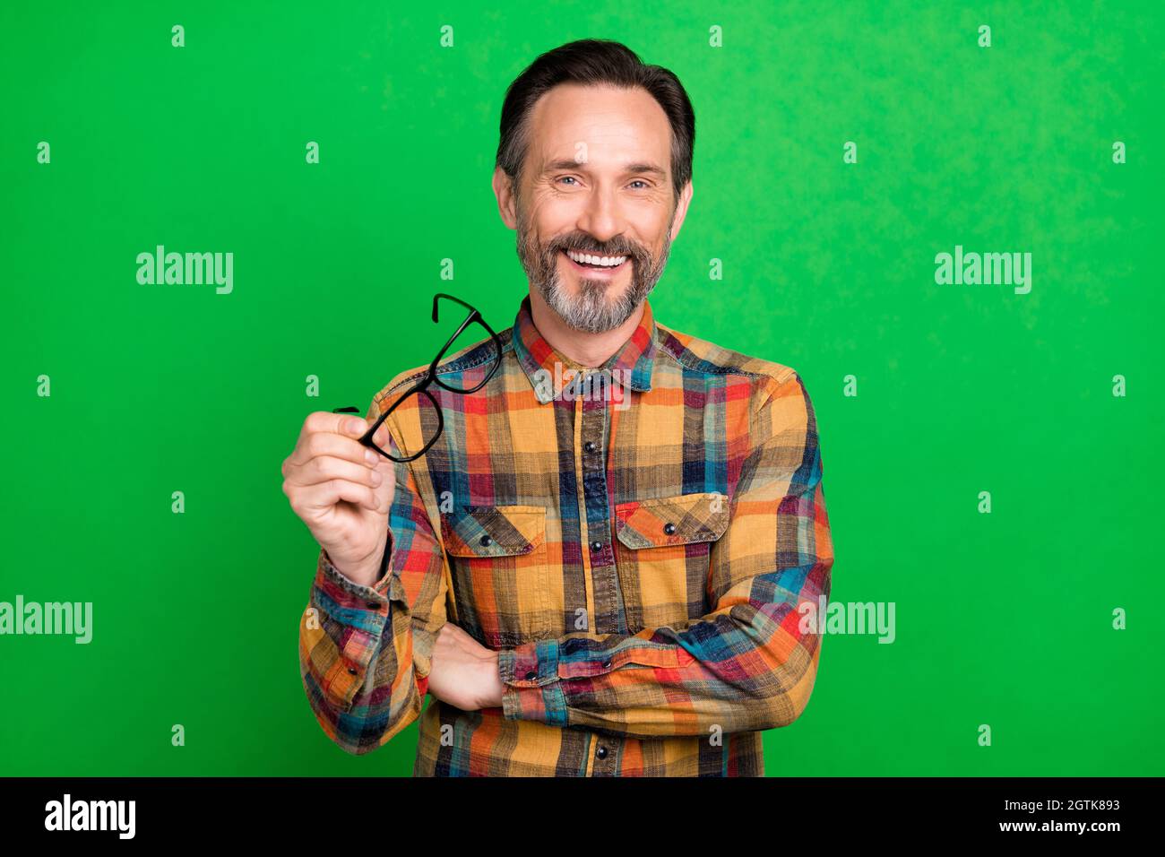 Portrait of attractive cheerful intellectual man holding in hands specs ...