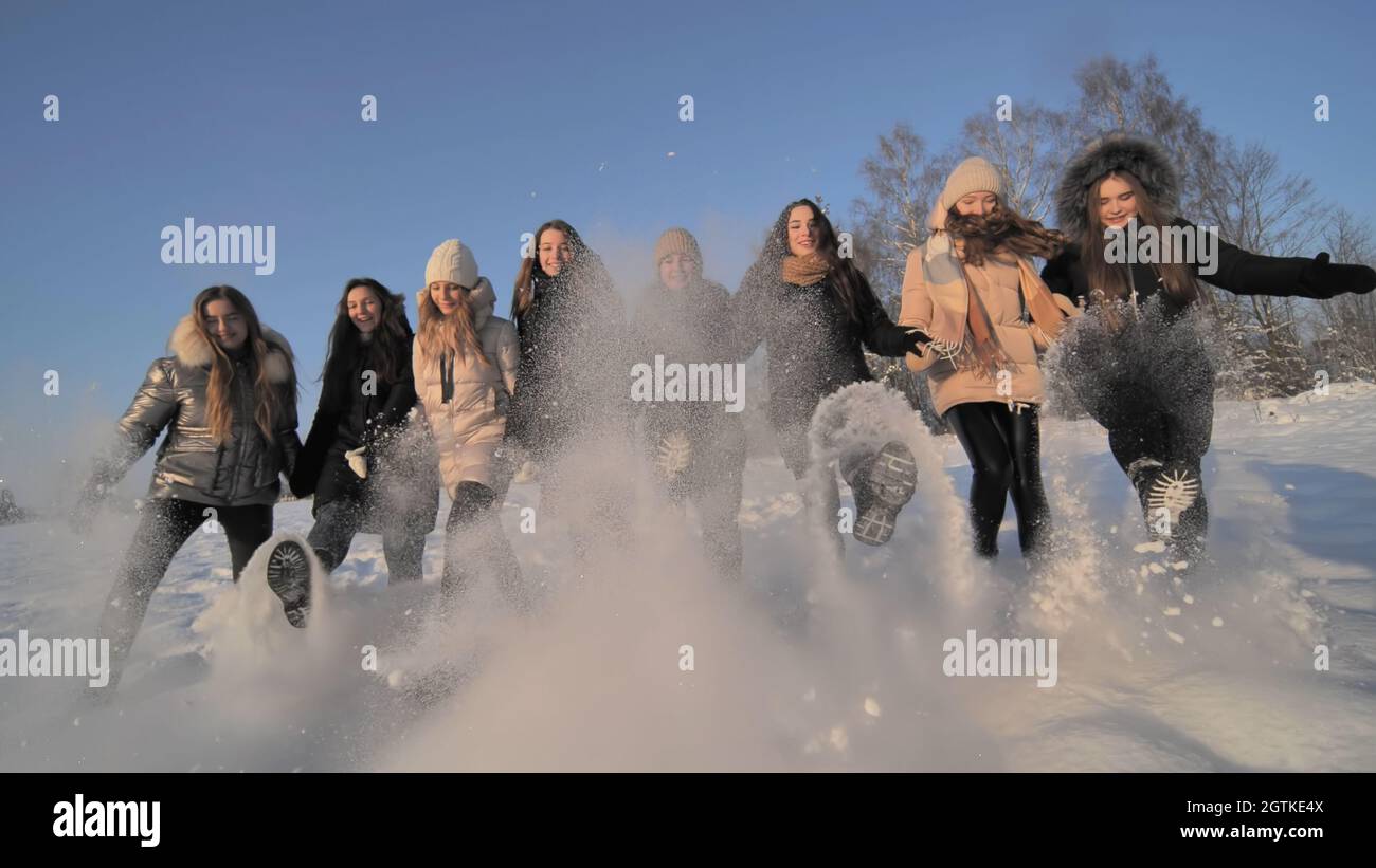 Cheerful girls friends kick the snow with their feet Stock Photo - Alamy