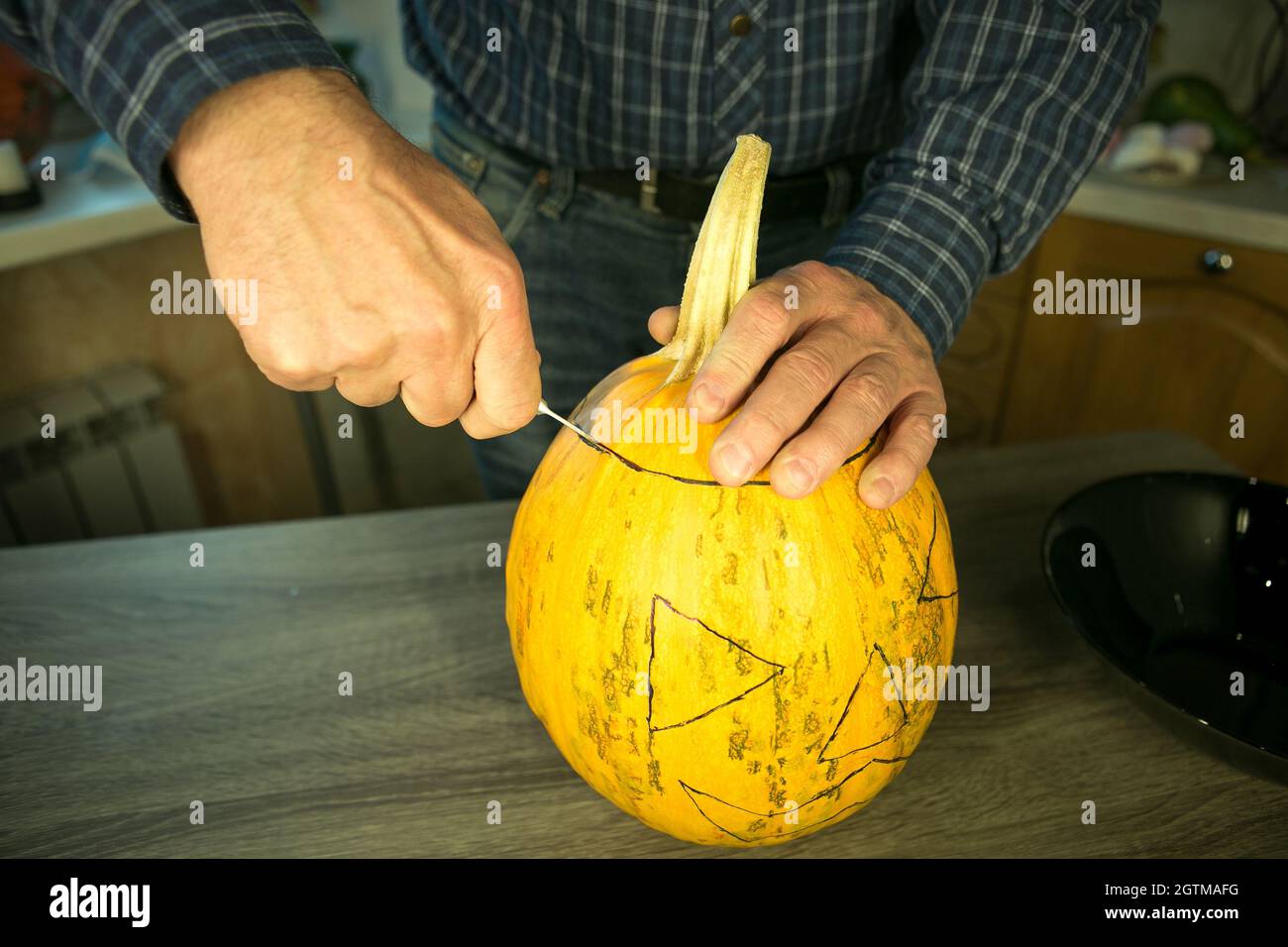 Halloween. How to make Jack O'Lantern at home? Male hands with knife ...