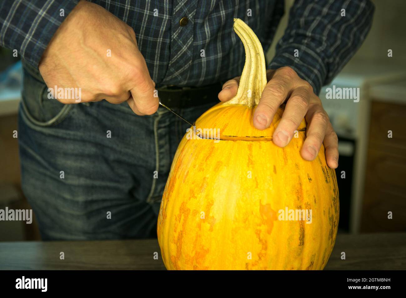 Halloween. How to make Jack O'Lantern at home? Male hands with knife ...