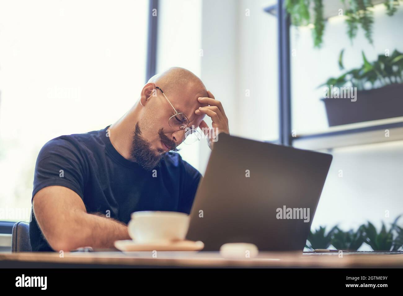 Unhappy man put his hand on head, tired businessman sits at work desk ...