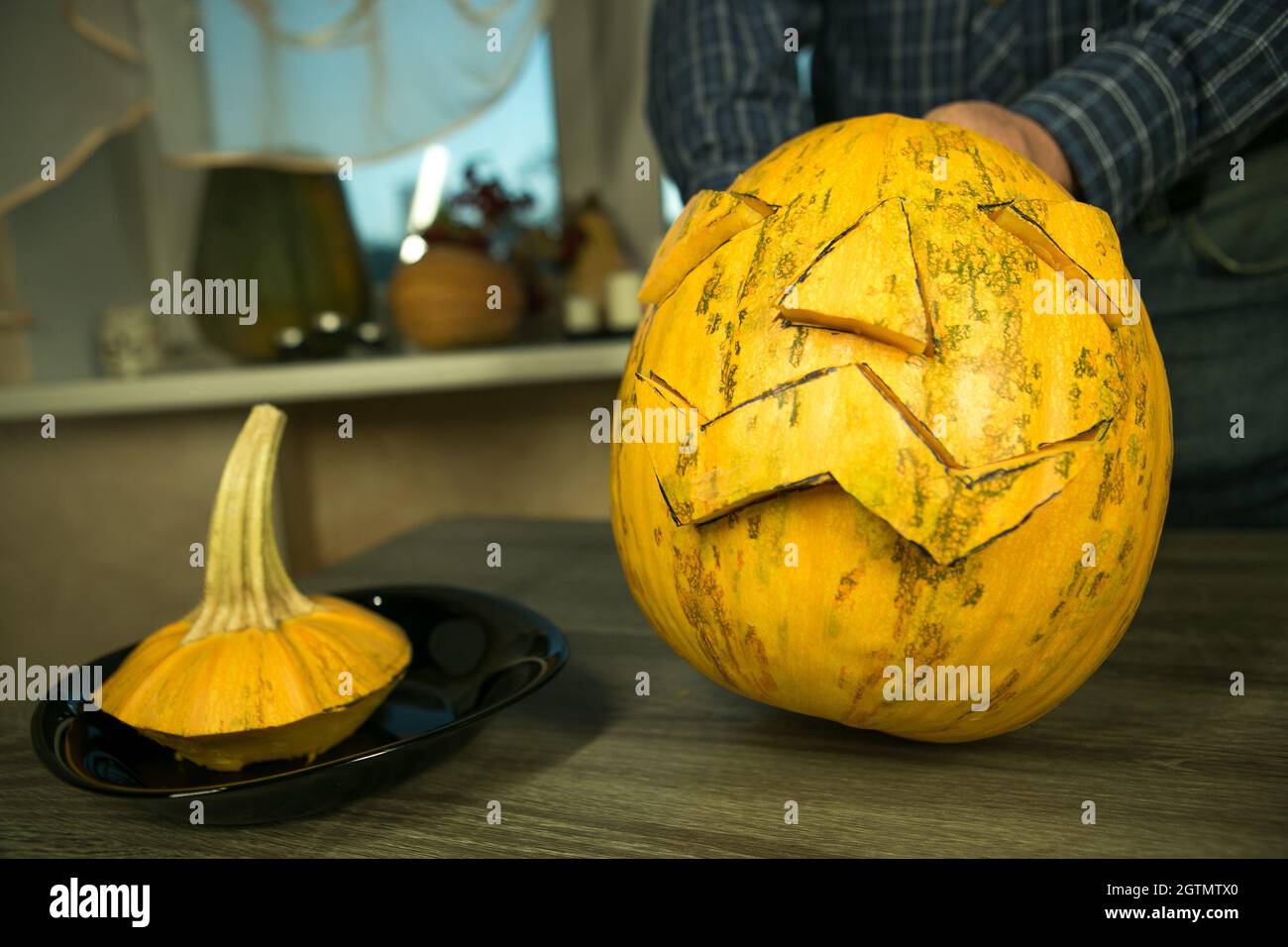 How to make Jack O'Lantern at home? Male hands with knife, leftovers of ...