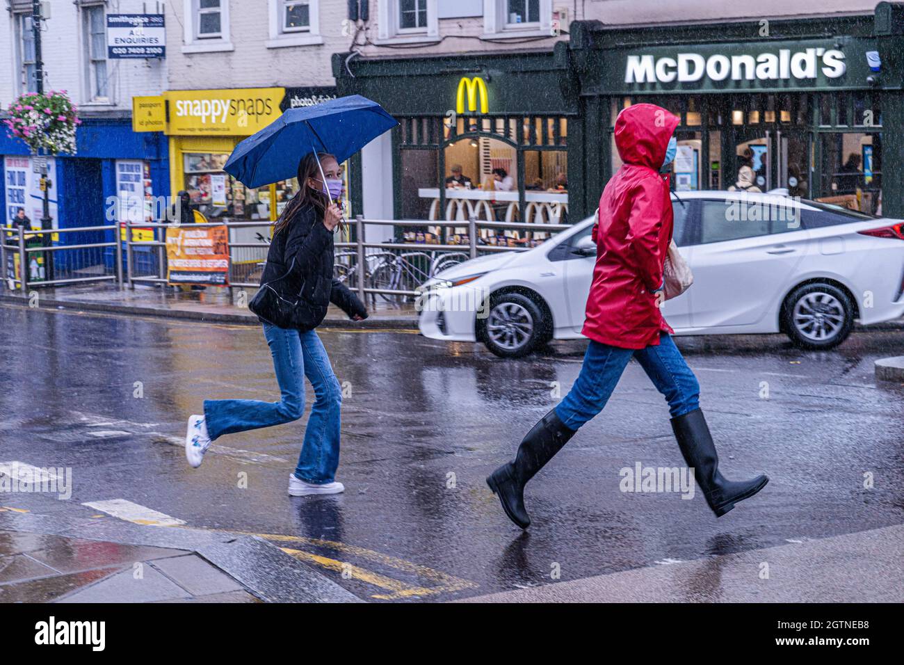 WIMBLEDON LONDON, UK. 2 OCTOBER, 2021. Pedestrians run for cover in ...