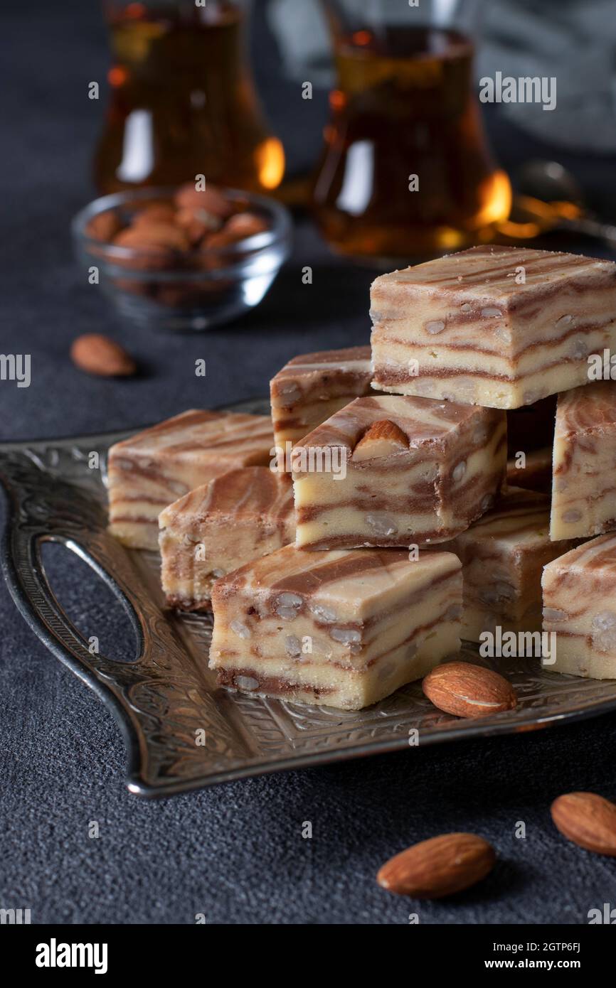 Delicious slices of Oriental milk halva with almonds and cocoa on dark ...