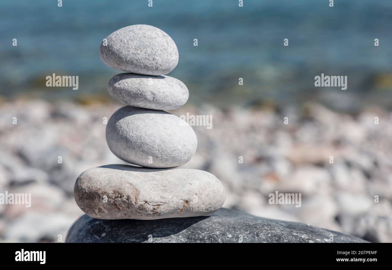 Balance, zen stones, smooth rock pyramid stacked on pebble beach, blue ...