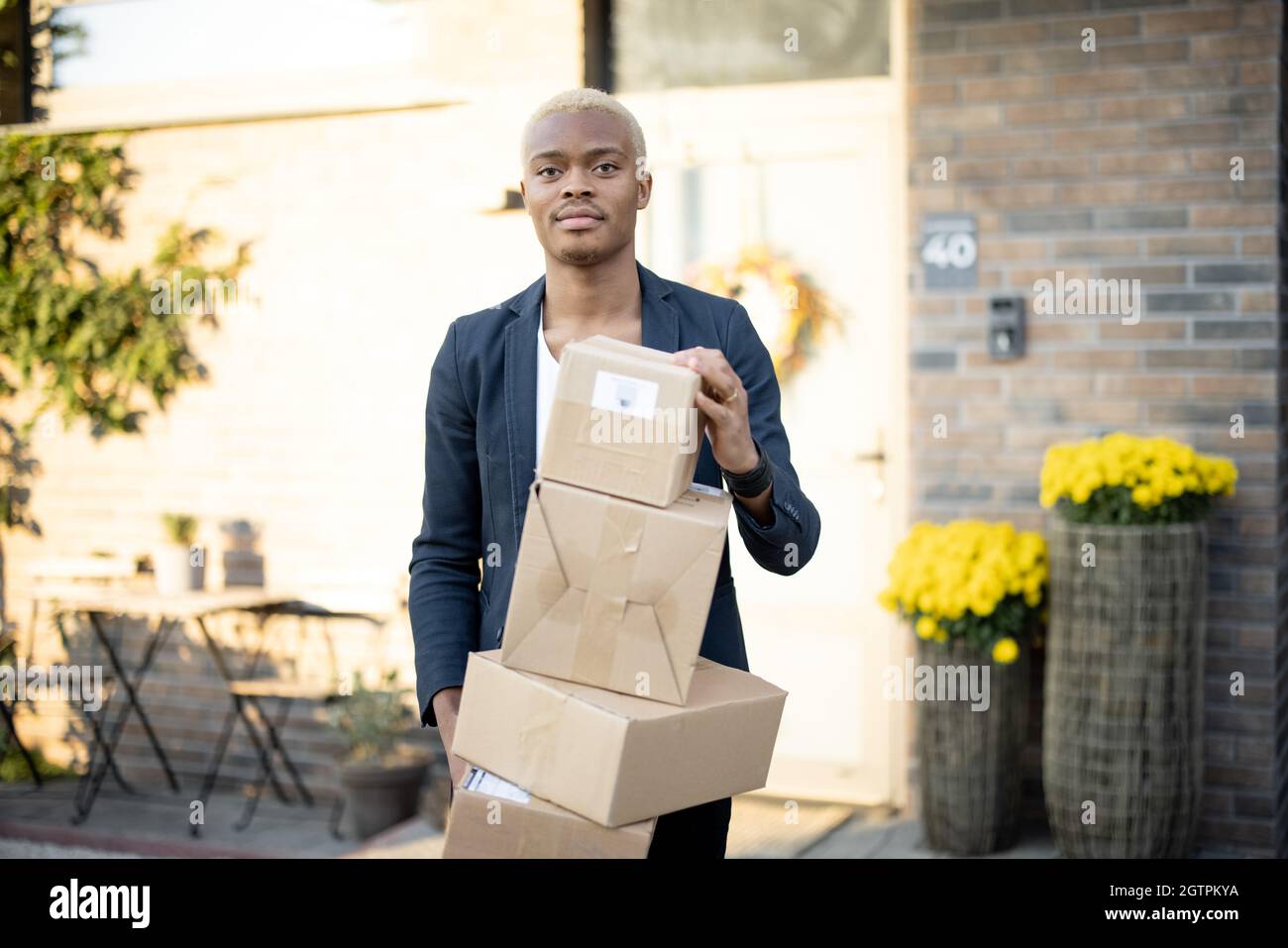 Black delivery man holding package hi-res stock photography and images ...