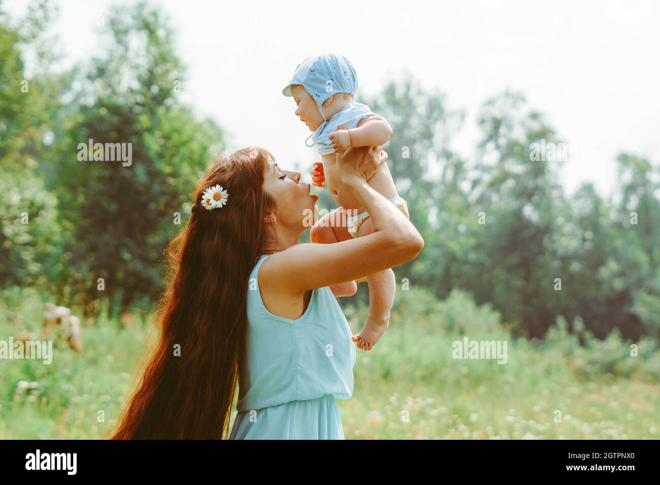 mother raises the child in her arms Stock Photo - Alamy
