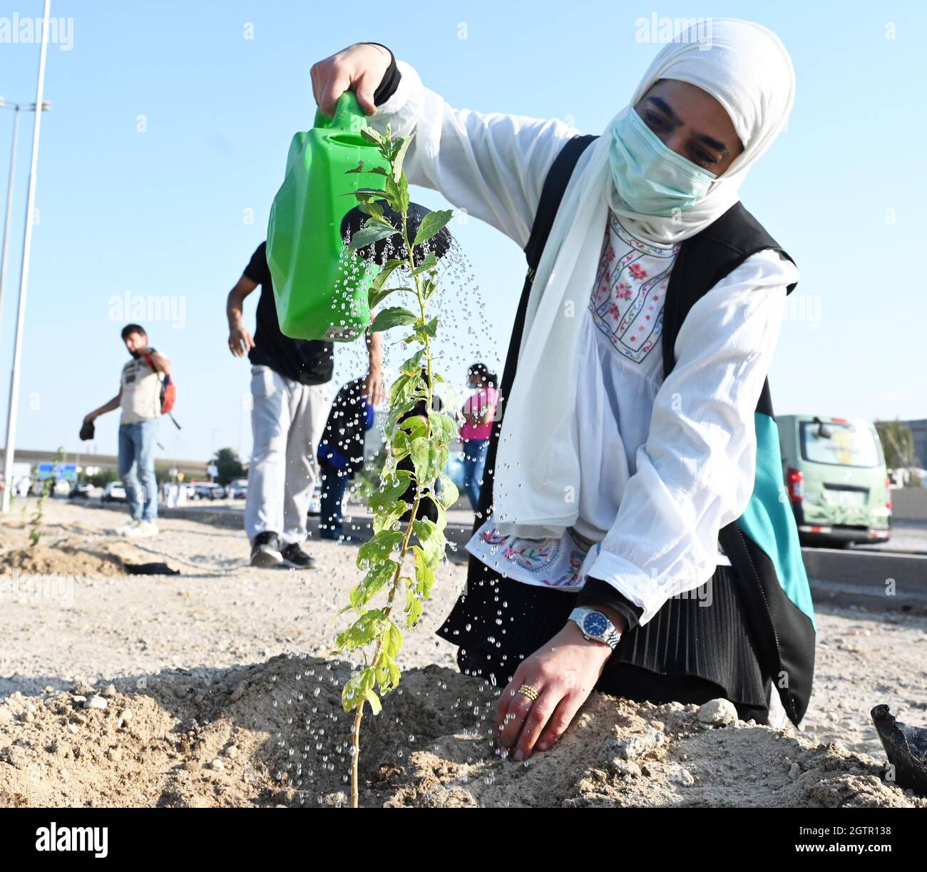 Capital Governorate, Kuwait. 2nd Oct, 2021. A woman waters a sapling ...