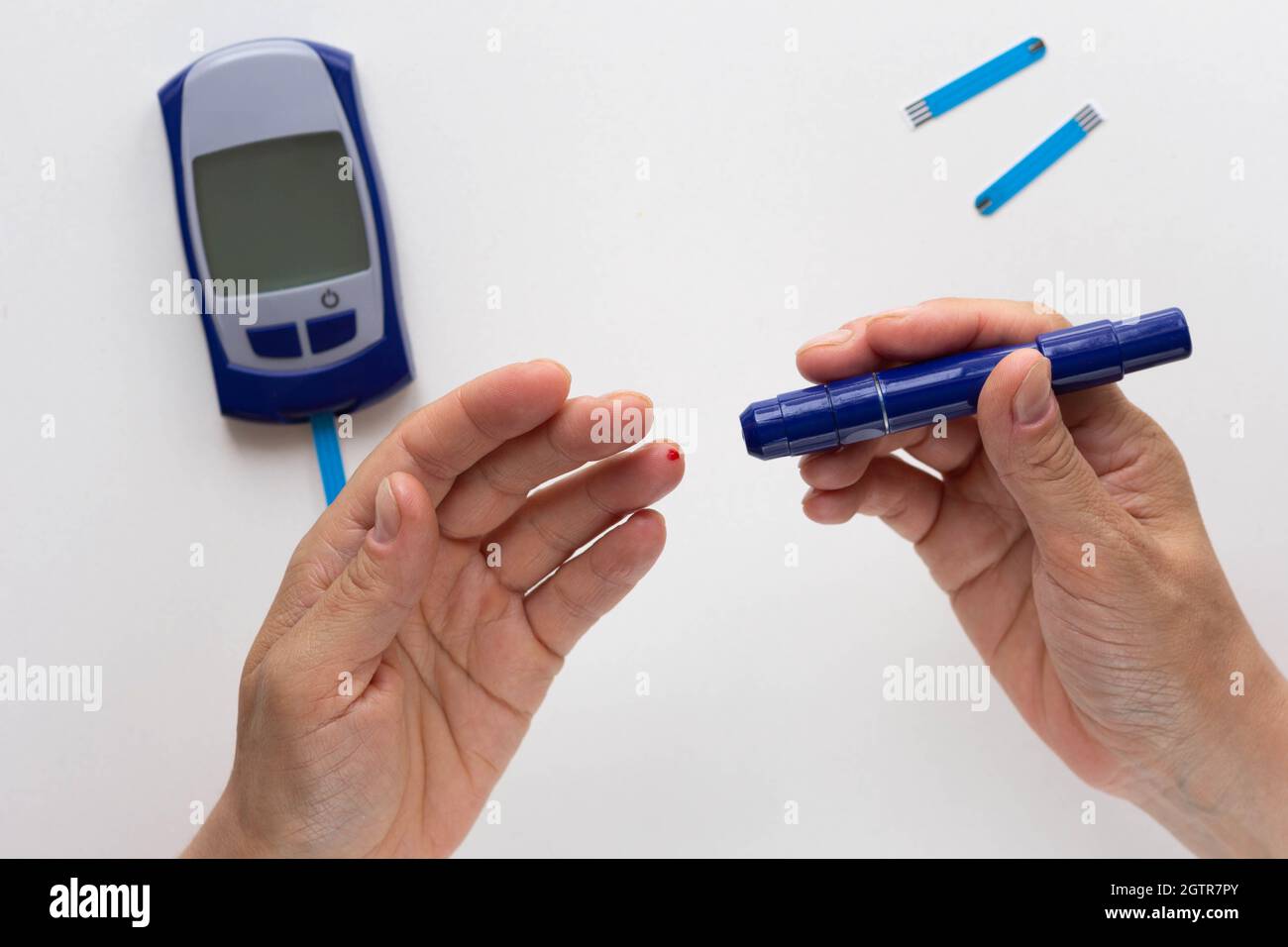 Top view of woman hand after pricking finger with blood drop on it to ...