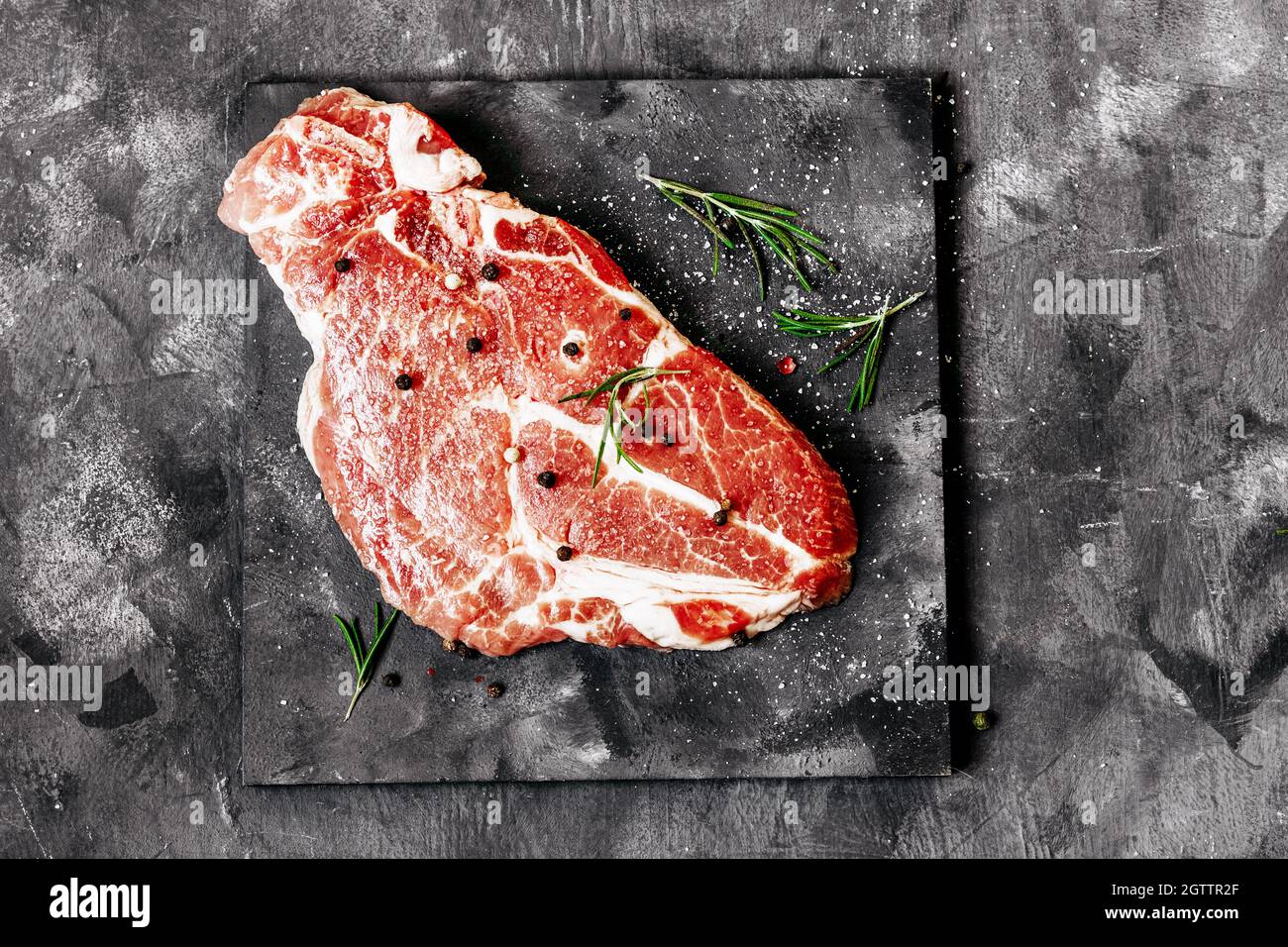 Raw marble pork steak on a dark board Stock Photo - Alamy