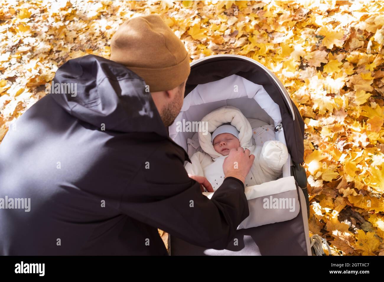 Happy young father with pram sitting on bench in nature at park Stock ...