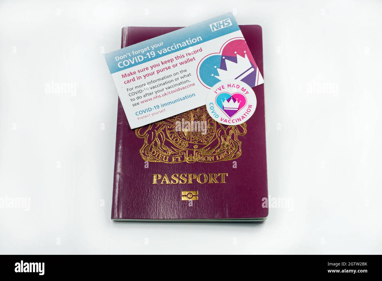 Covid vaccination proof card on a passport against a whit background ...