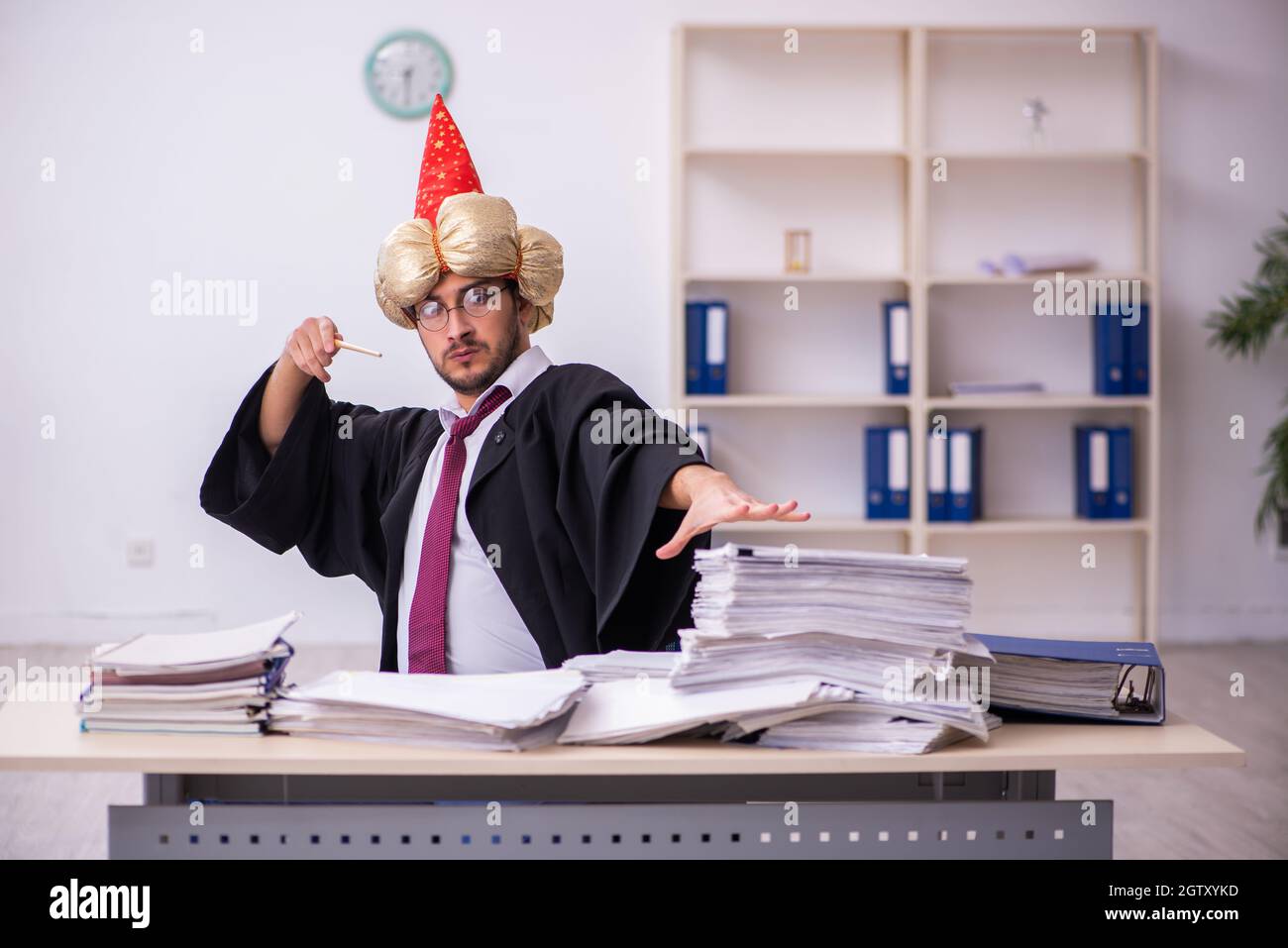 Funny young employee magician and too much work in the office Stock ...