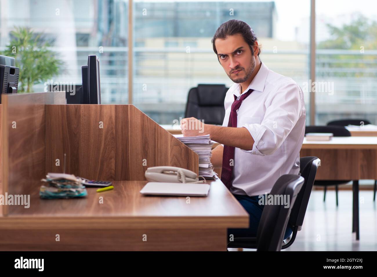 Young employee and too many work in the office Stock Photo - Alamy