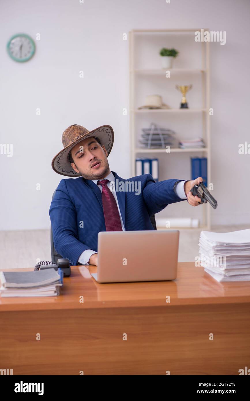 Young cowboy employee working at workplace Stock Photo - Alamy