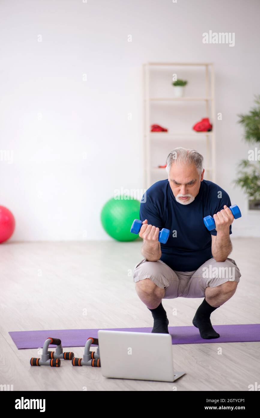 Old man doing sport exercises at home Stock Photo - Alamy