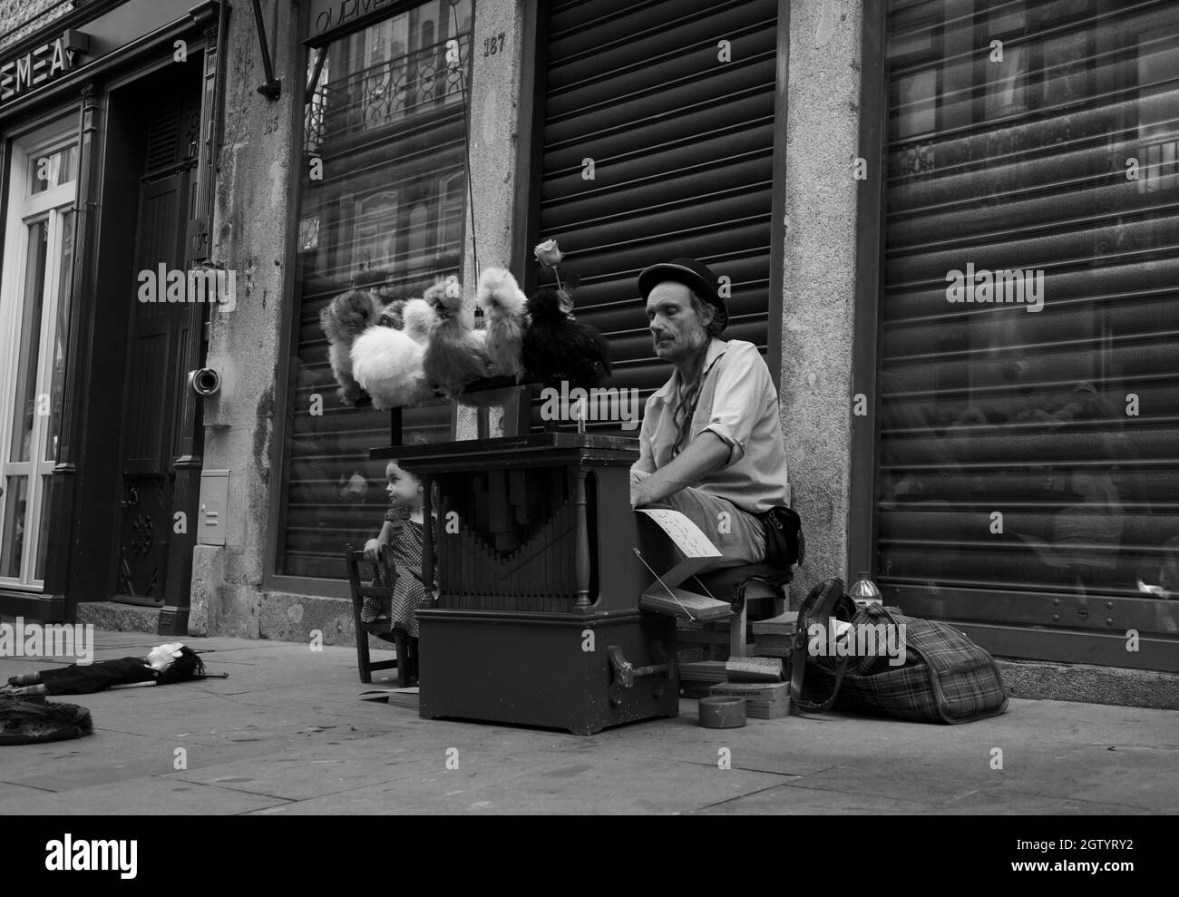 Busker playing a card based music box with chickens at Rua das Flores ...