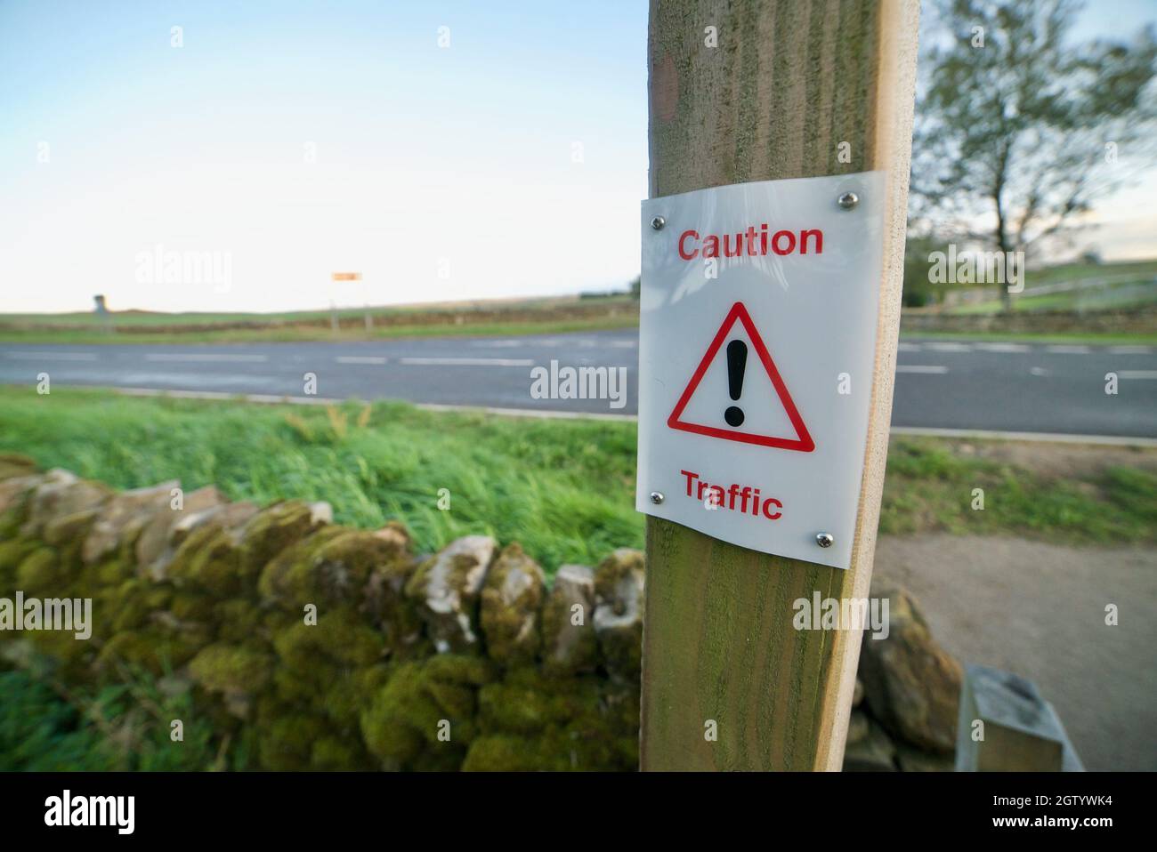Caution Traffic- Small warning road sign next to a country road for ... Caution Traffic- Small warning road sign next to a country road for ...