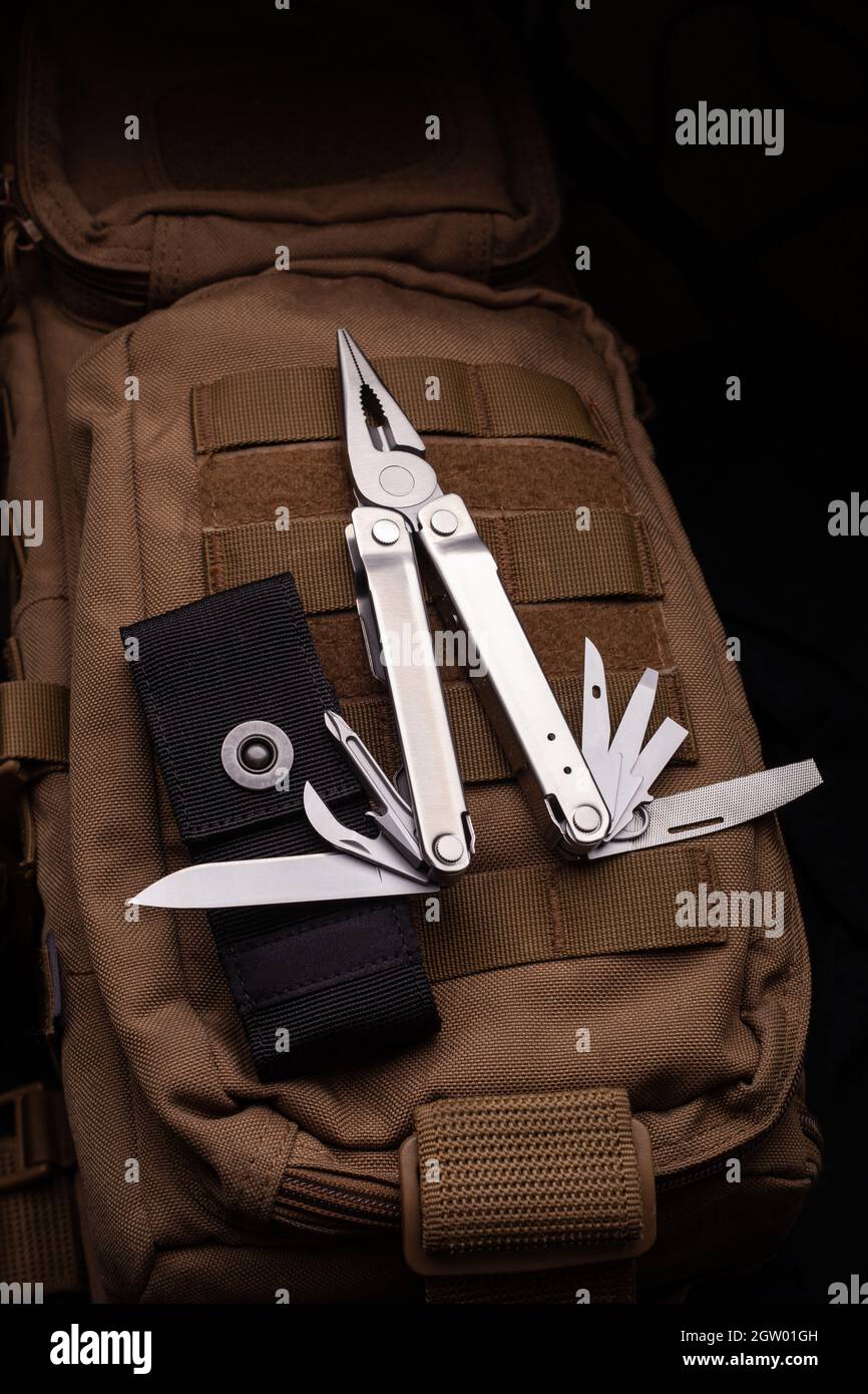 Modern multitool with many tools. A portable multitasking tool lie on a ...