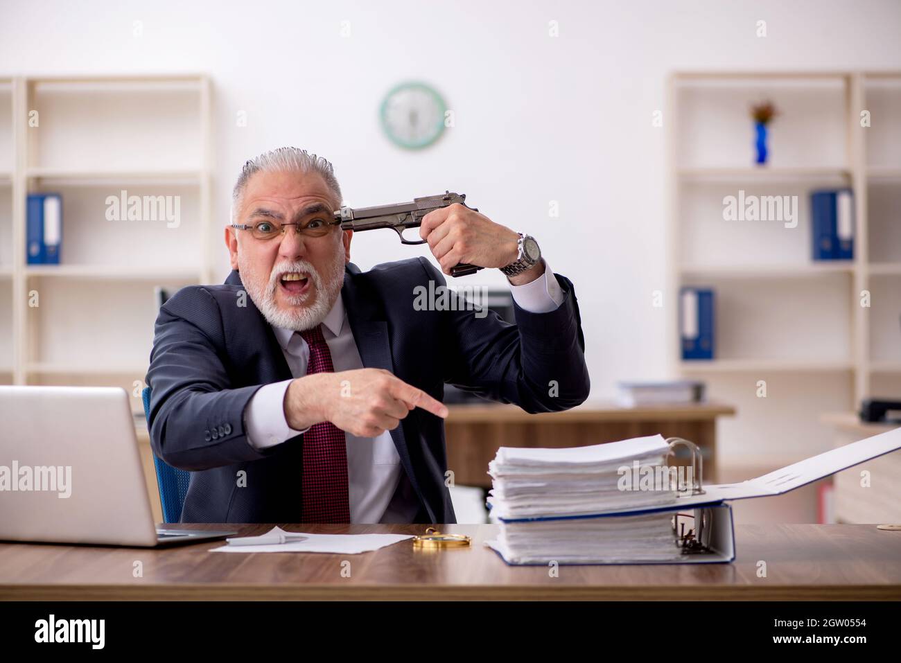 Old male employee holding gun at workplace Stock Photo - Alamy