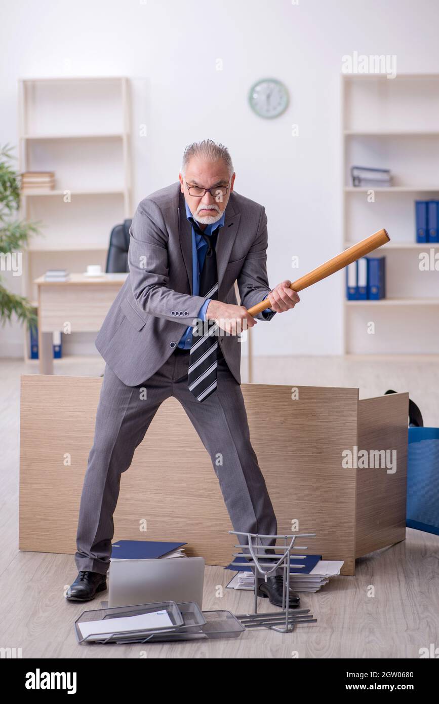 Old businessman employee holding baseball bat in the office Stock Photo ...