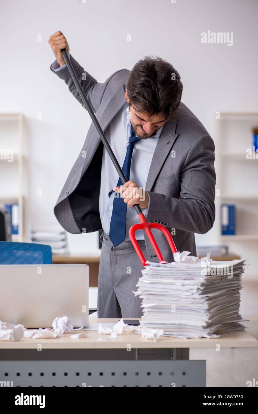 Young employee and too much work in the office Stock Photo - Alamy