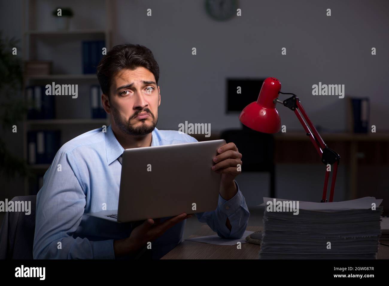 Young employee working late in the office Stock Photo - Alamy