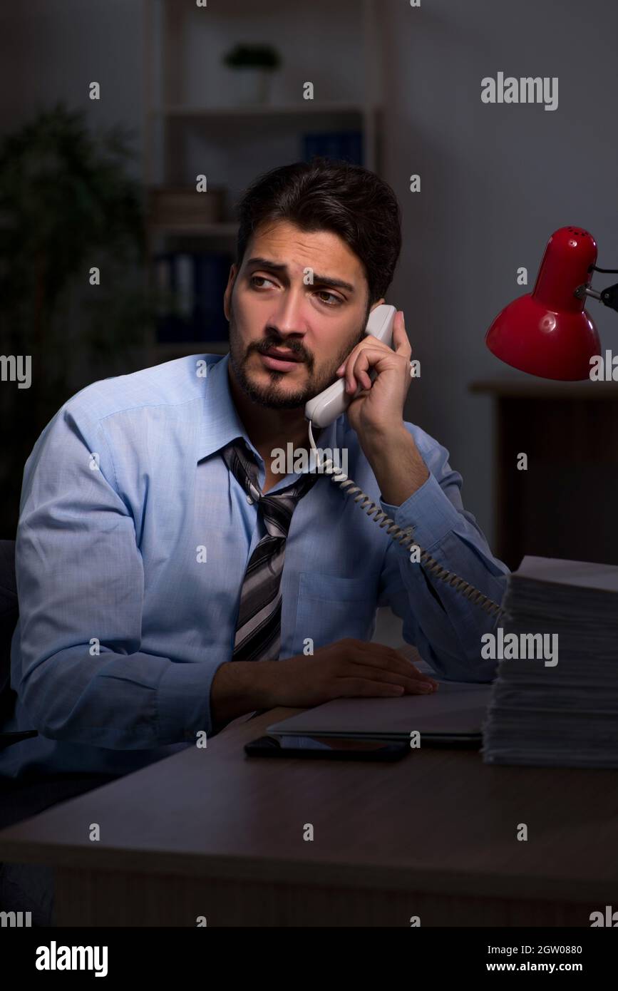 Young employee working late in the office Stock Photo - Alamy