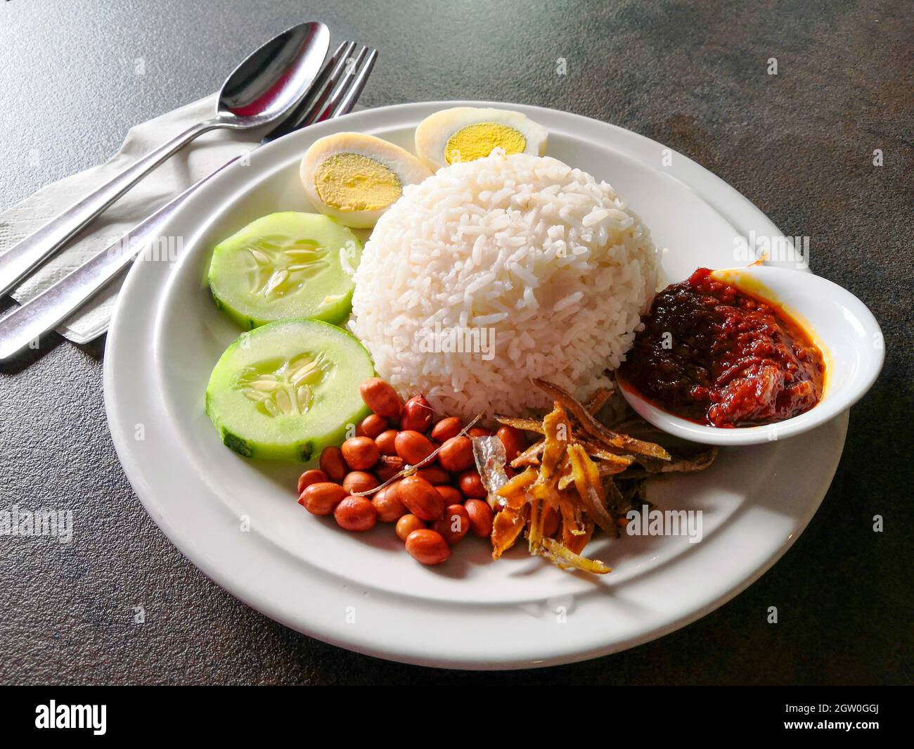 Malaysia Famous Nasi Lemak Served With Fried Anchovies Nuts Cucumbers And Boiled Egg Stock