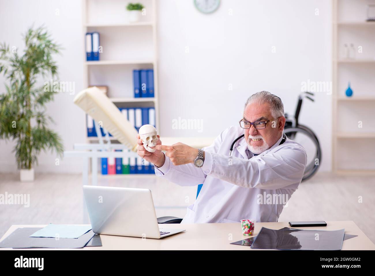 Old doctor demonstrating human skull Stock Photo - Alamy