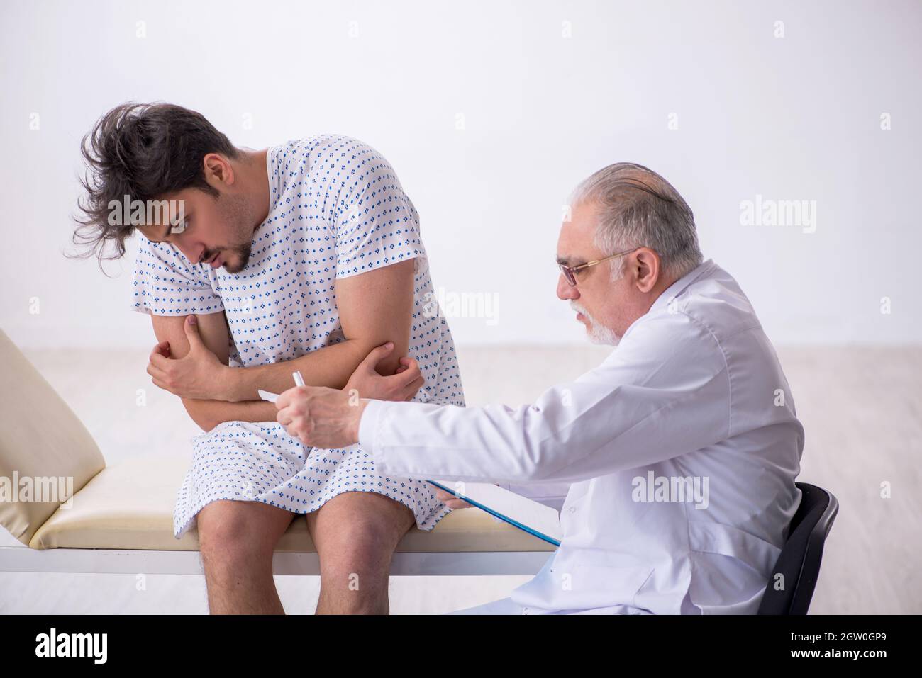 Old doctor psychiatrist examining young male patient Stock Photo - Alamy