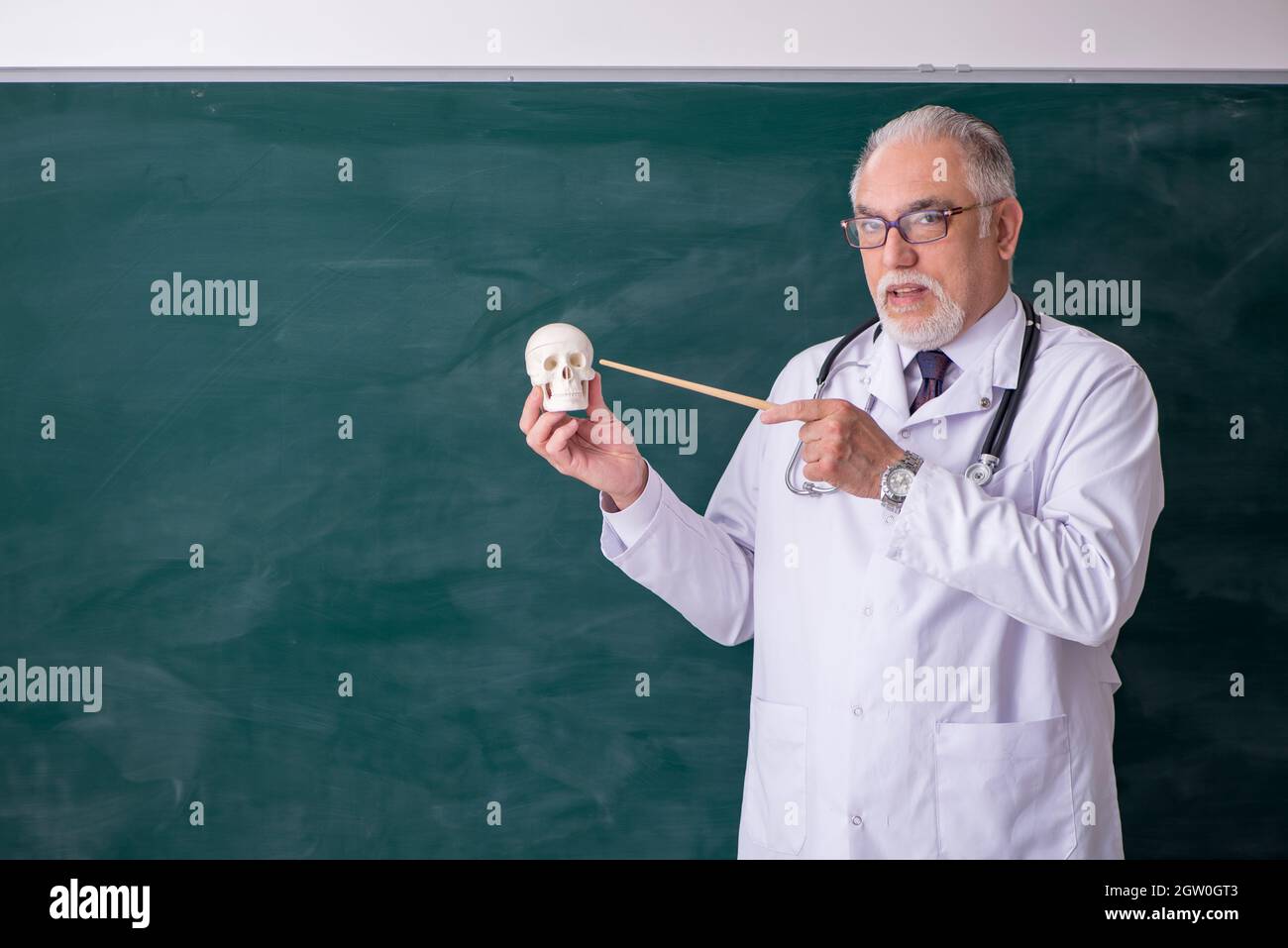 Old doctor teacher in front of blackboard Stock Photo - Alamy