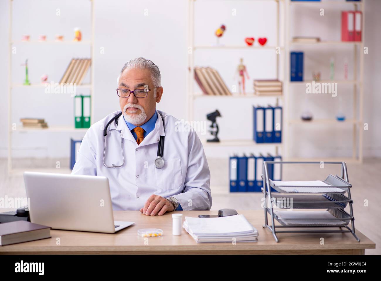 Old doctor working in the clinic Stock Photo - Alamy