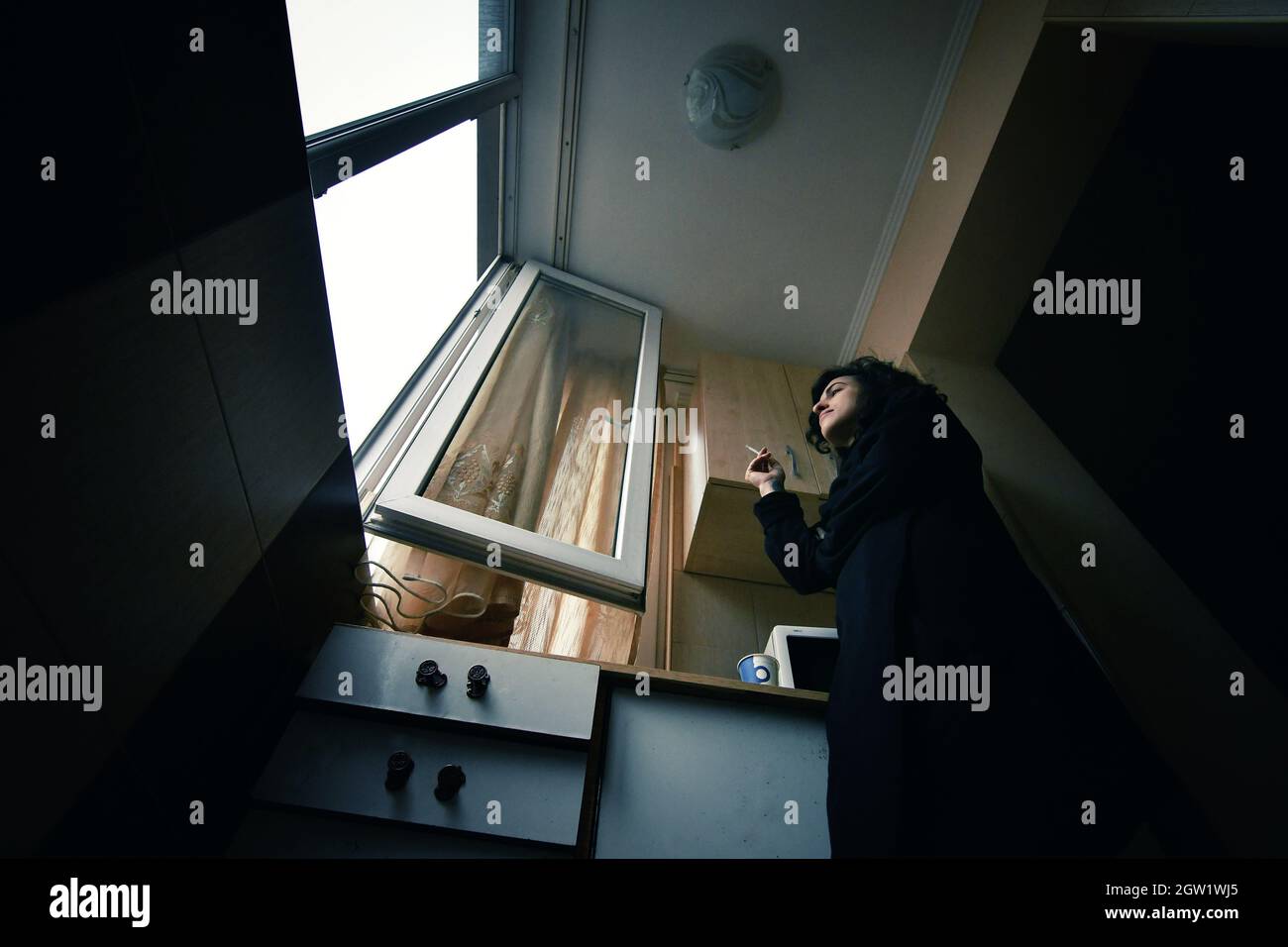 Young Woman Smoking By Window At Home Stock Photo - Alamy