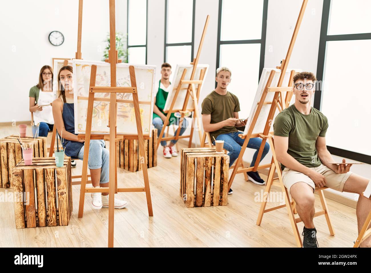 Group of young people drawing at art studio scared and amazed with open ...