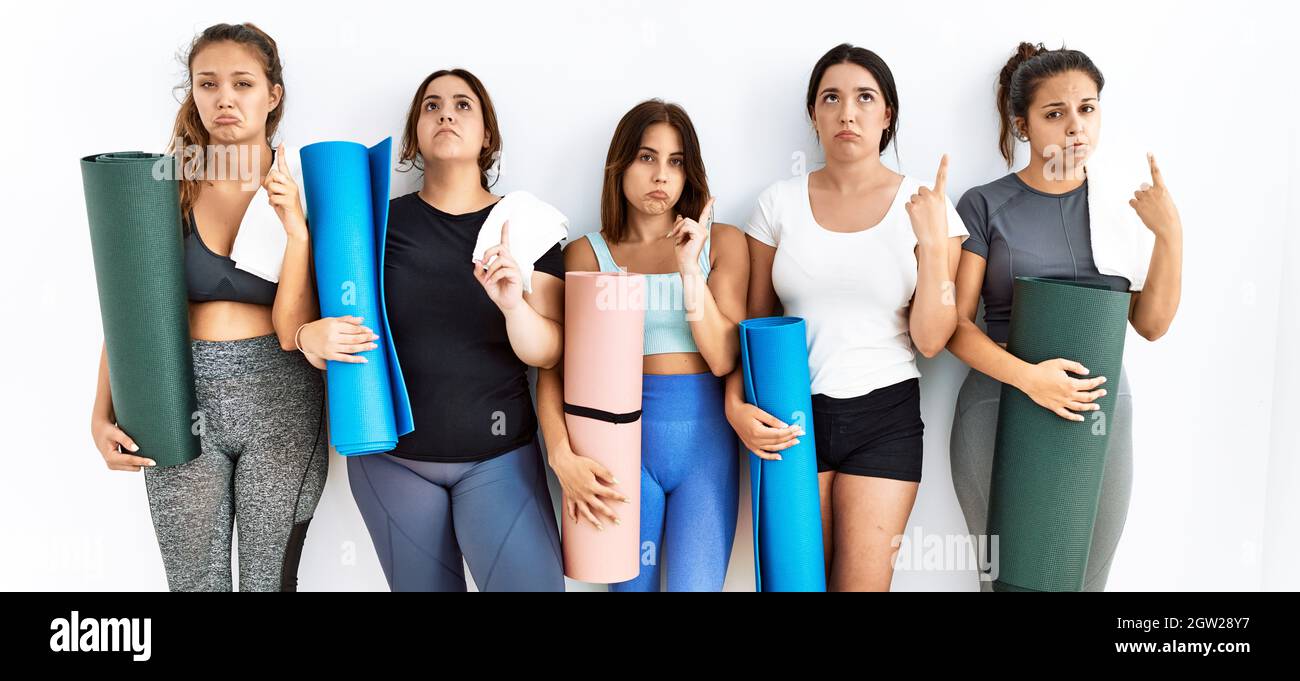 Group of women holding yoga mat standing over isolated background ...