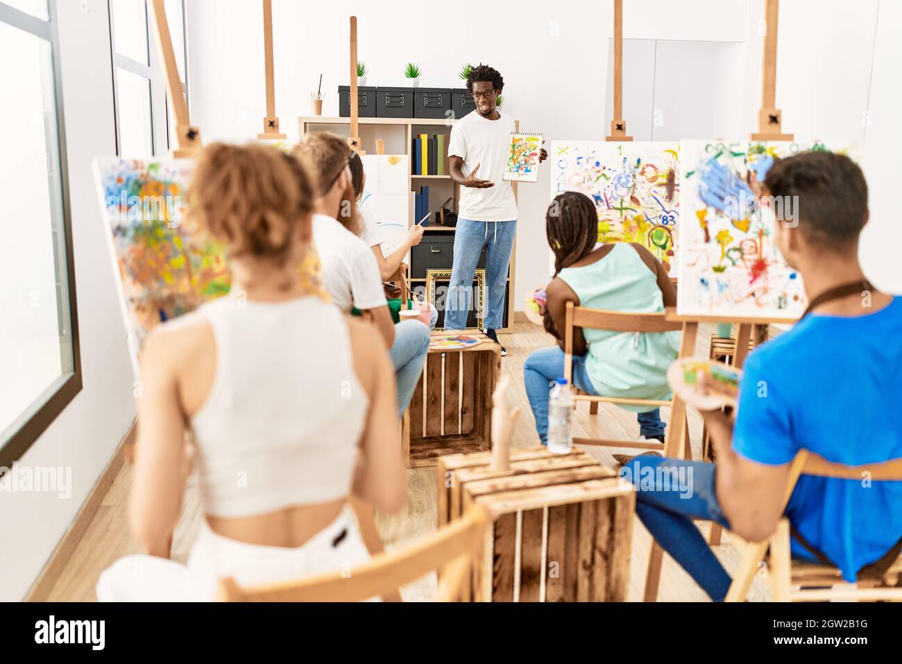 Group of people smiling happy drawing in paint class at art studio ...