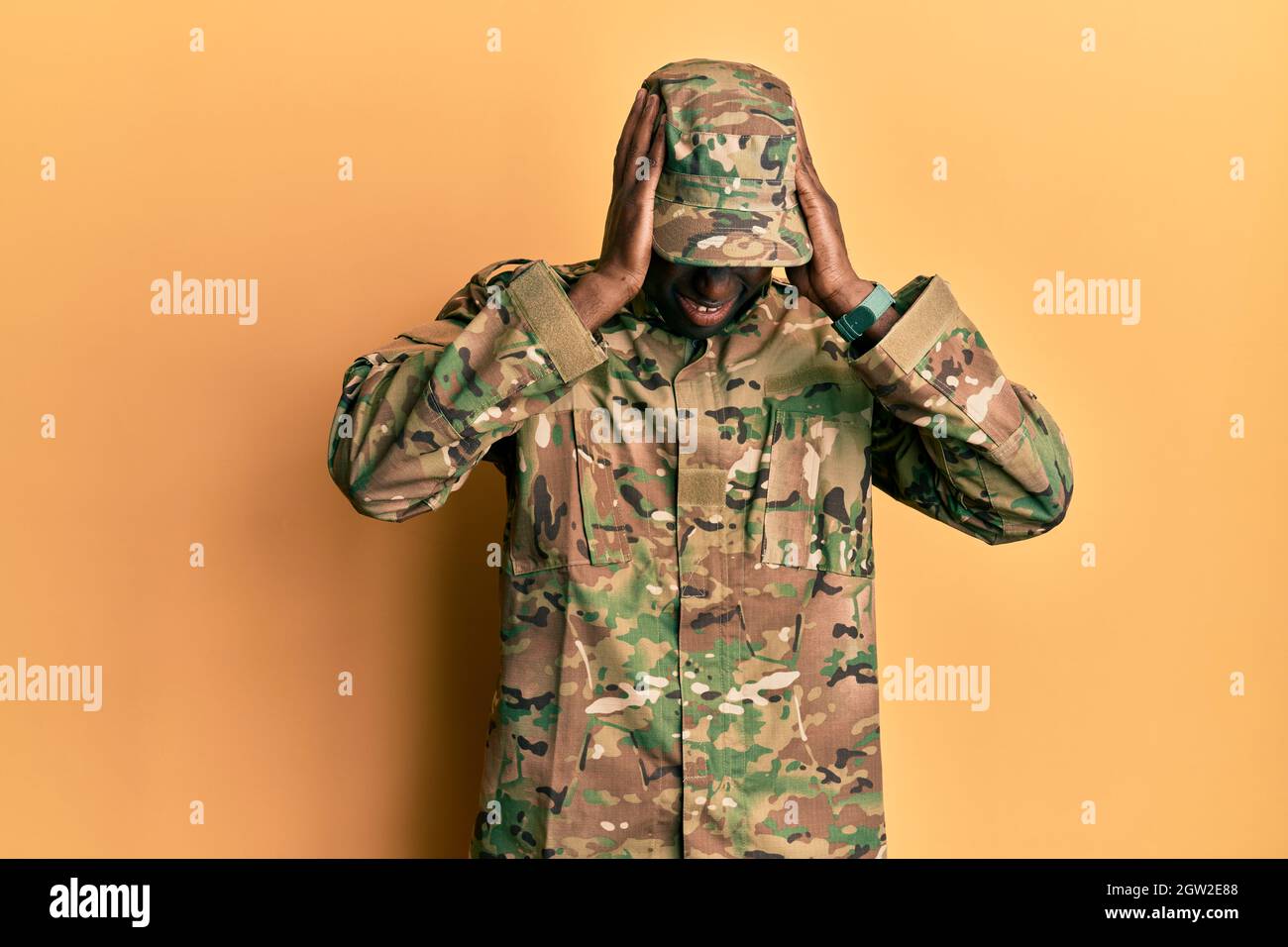Young african american man wearing army uniform suffering from headache ...