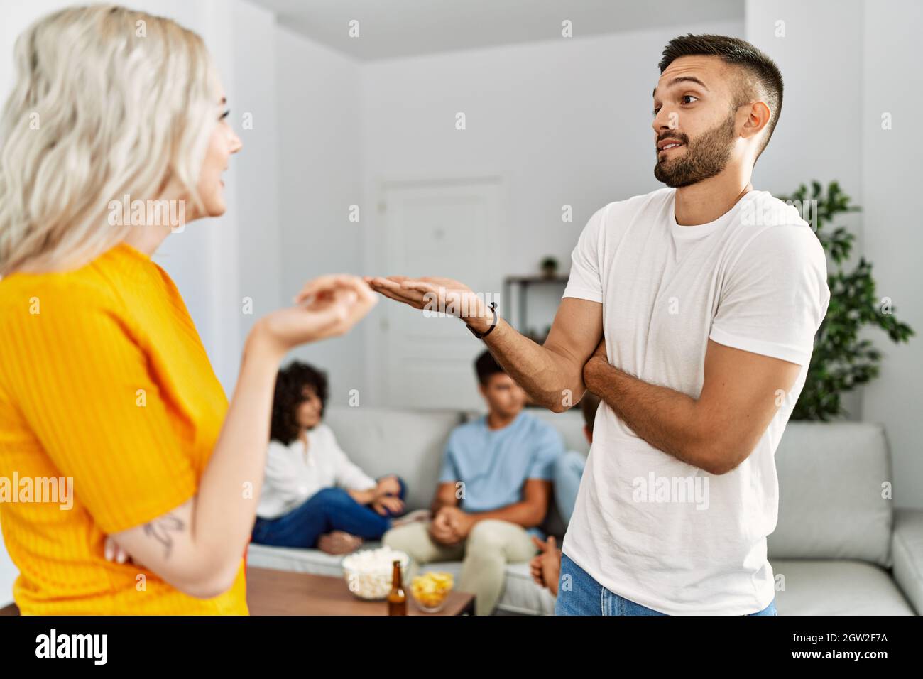 Two young friends standing and speaking at home Stock Photo - Alamy