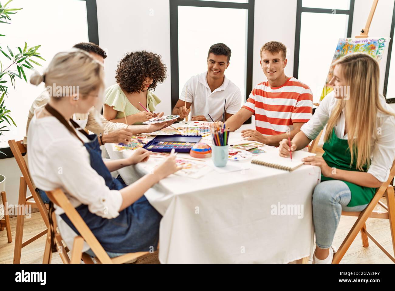 Group of people smiling happy drawing sitting on the table at art ...