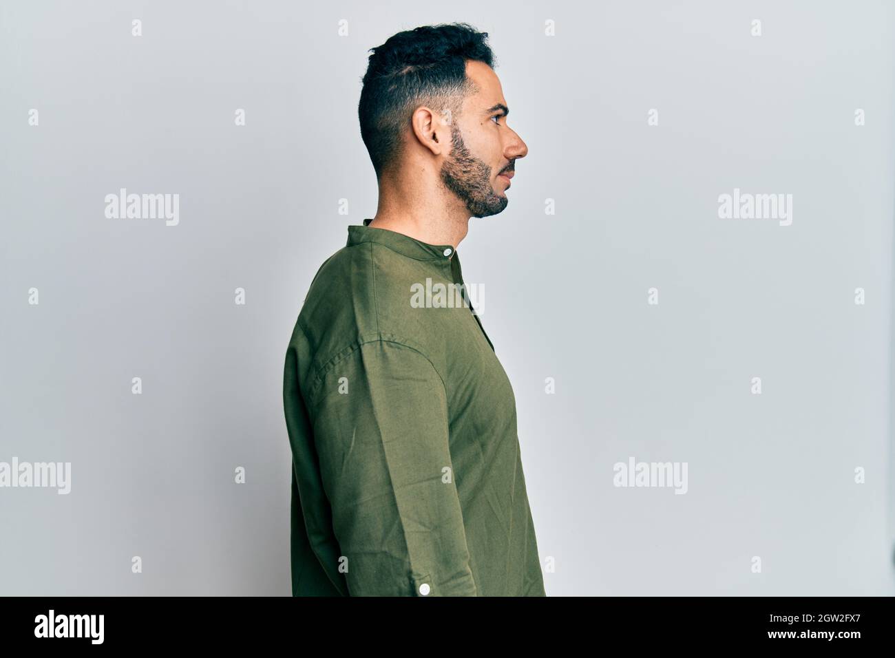 Young hispanic man wearing casual clothes looking to side, relax ...