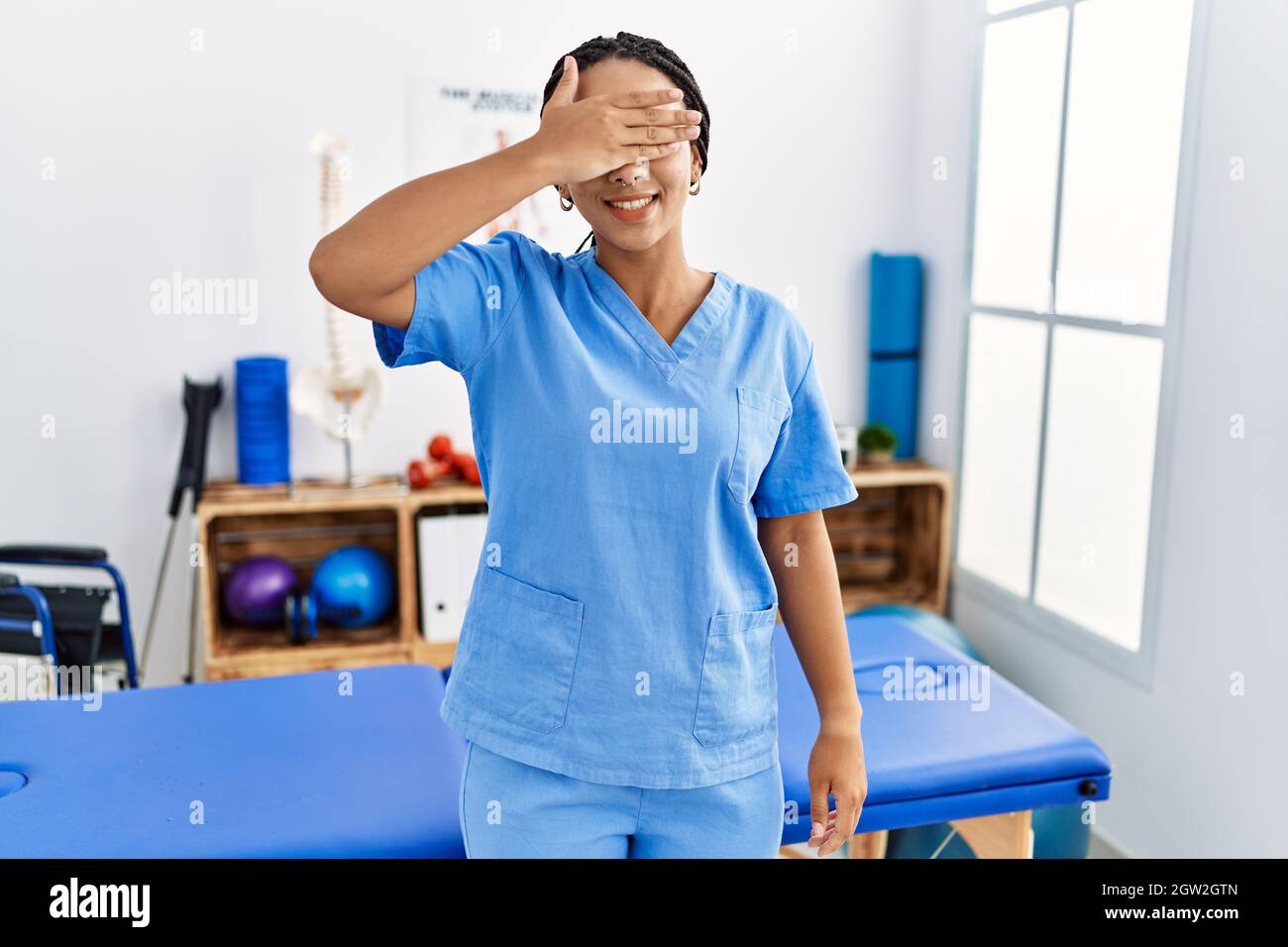 Young african american woman working at pain recovery clinic smiling ...